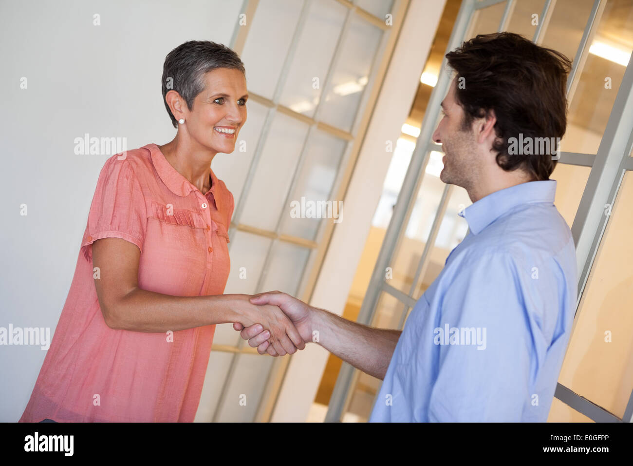 Casual smiling business people shaking hands Stock Photo - Alamy