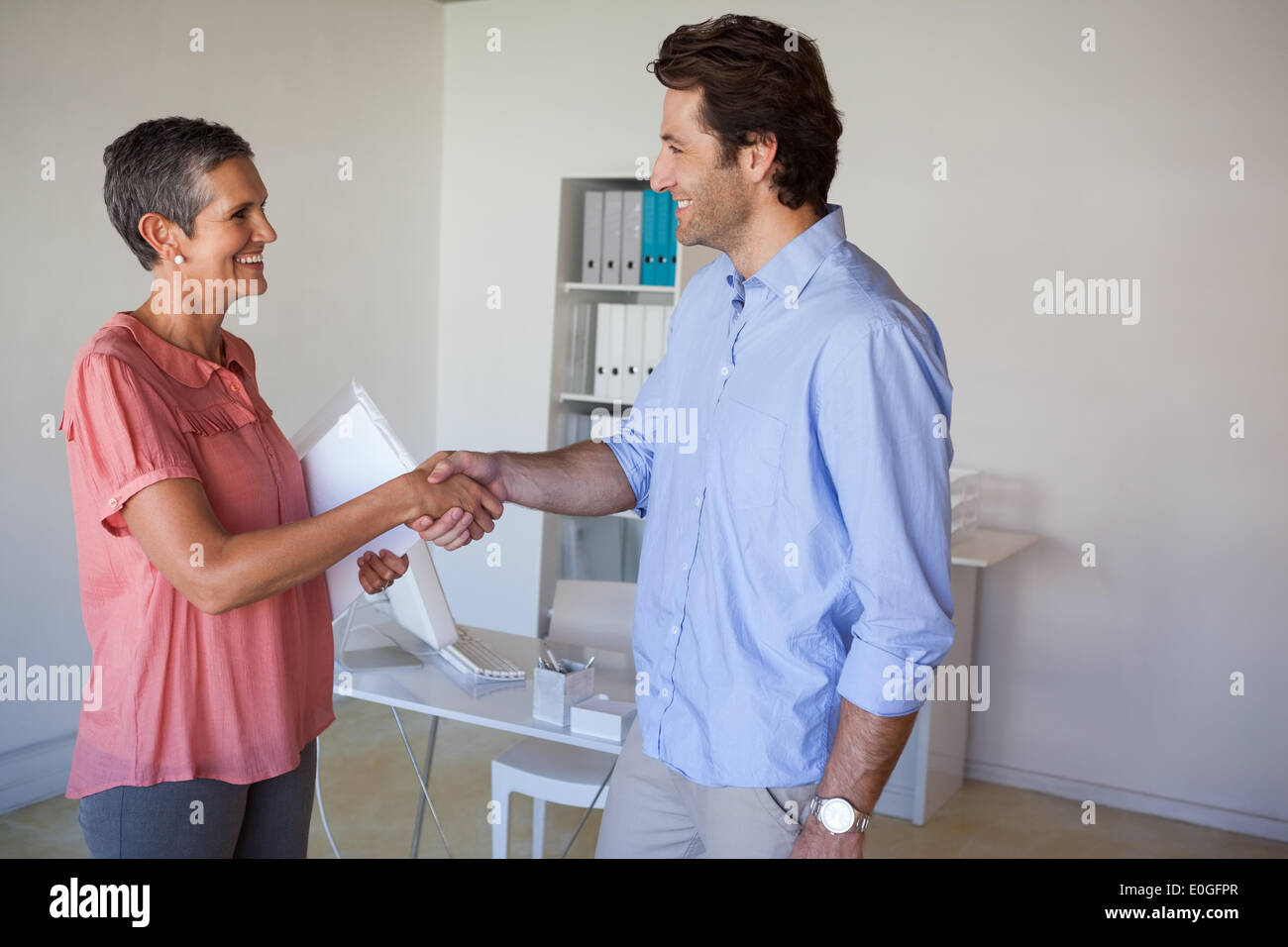 Casual smiling business people shaking hands Stock Photo - Alamy