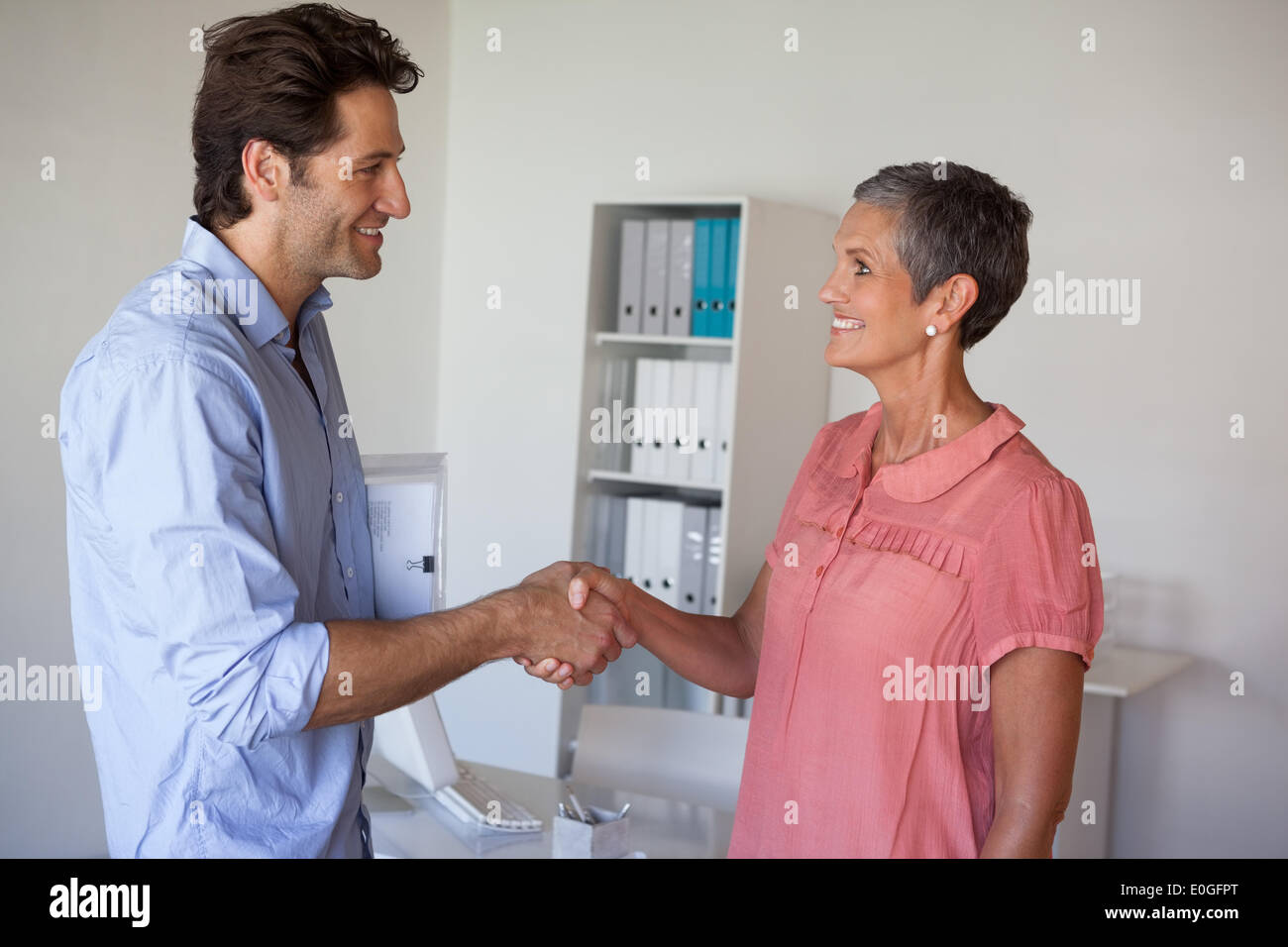 Casual smiling business people shaking hands Stock Photo - Alamy