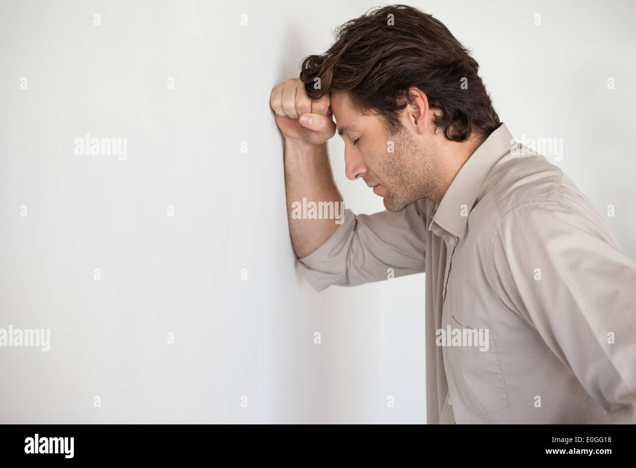 Business man leaning head to wall hi-res stock photography and images ...