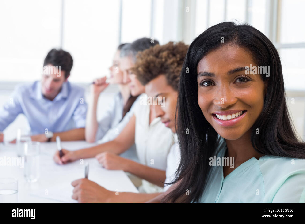 Casual businesswoman smiling at camera during meeting in the office ...