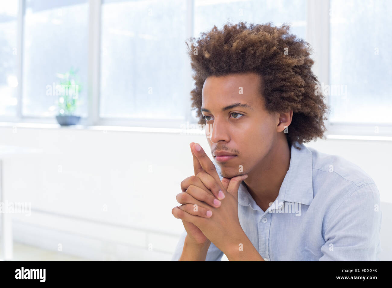 Attractive businessman thinking with hands together Stock Photo - Alamy