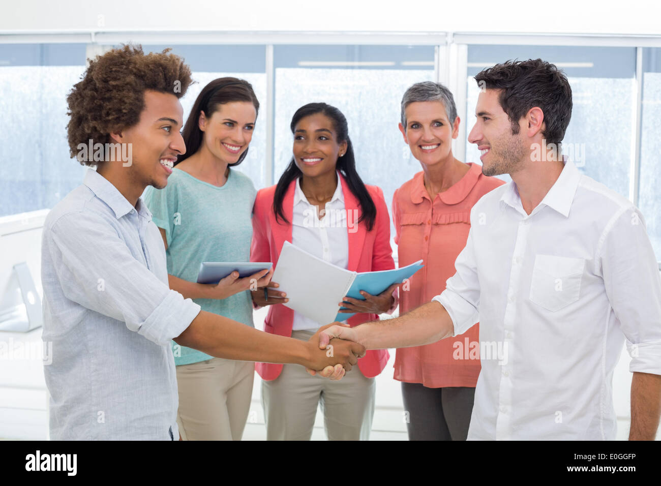 Attractive businessmen shaking hands at work Stock Photo - Alamy