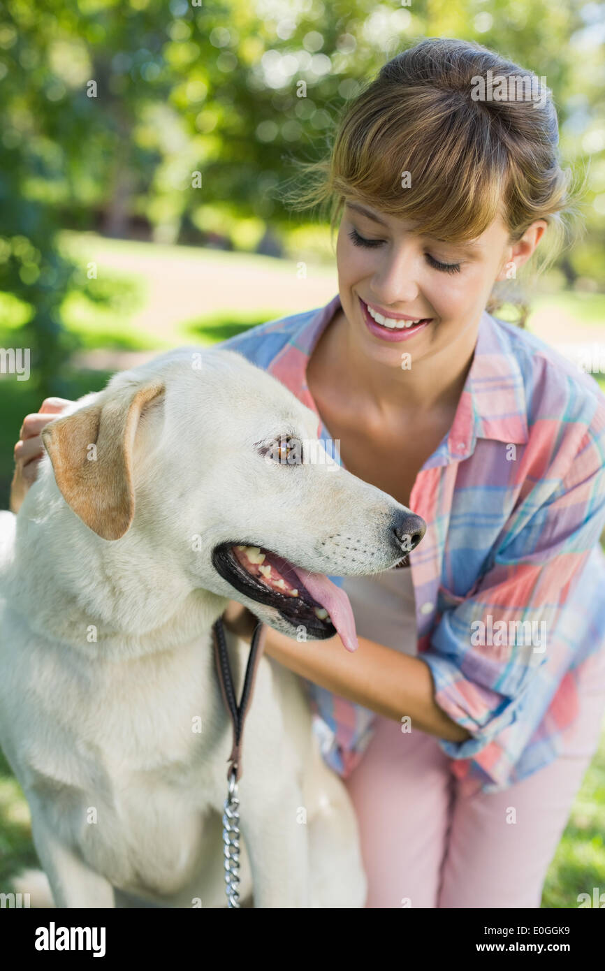 Pretty smiling blonde posing with her labrador in the park Stock Photo ...