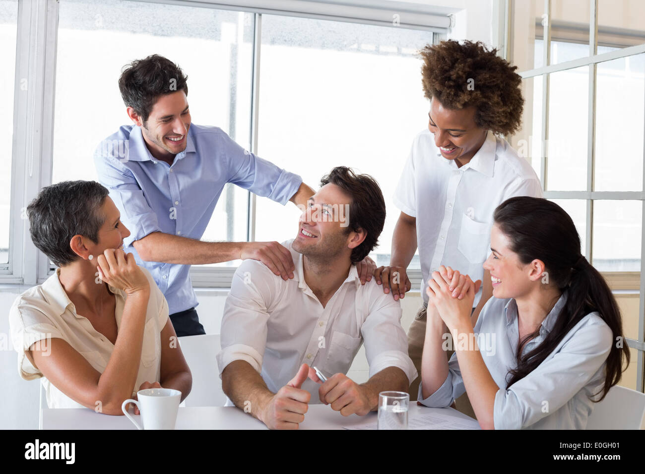Attractive businessman praising coworker Stock Photo - Alamy