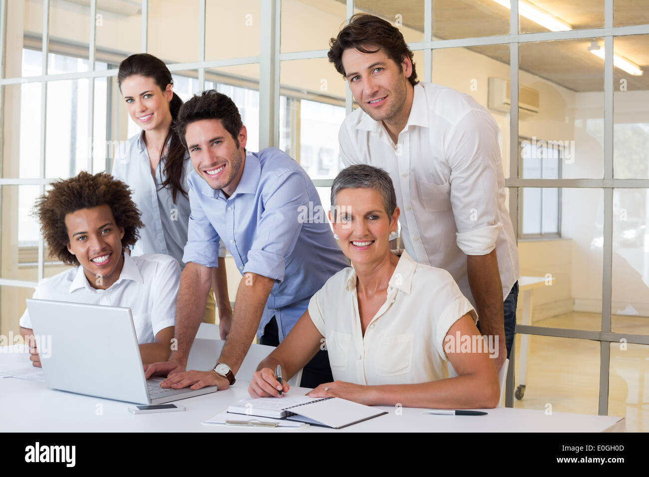 Workers using laptop smile to camera Stock Photo - Alamy