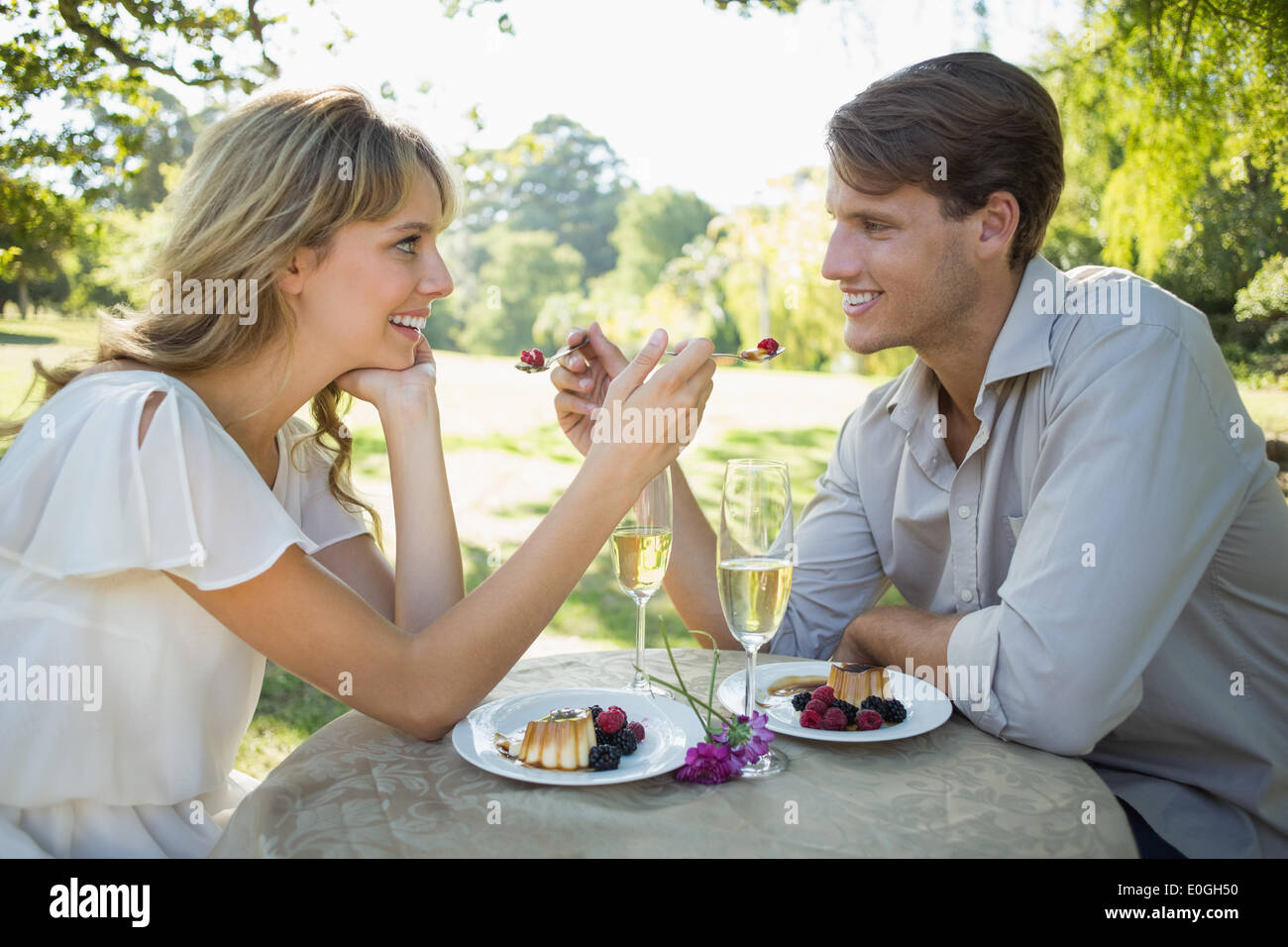 Cute couple feeding each other dessert Stock Photo - Alamy
