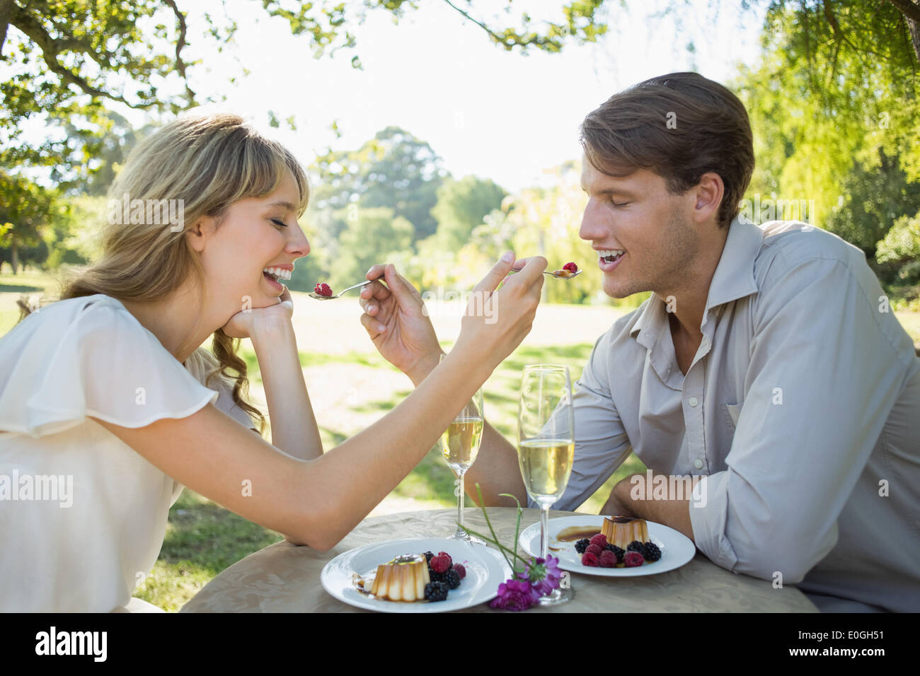 Cute couple feeding each other dessert Stock Photo - Alamy