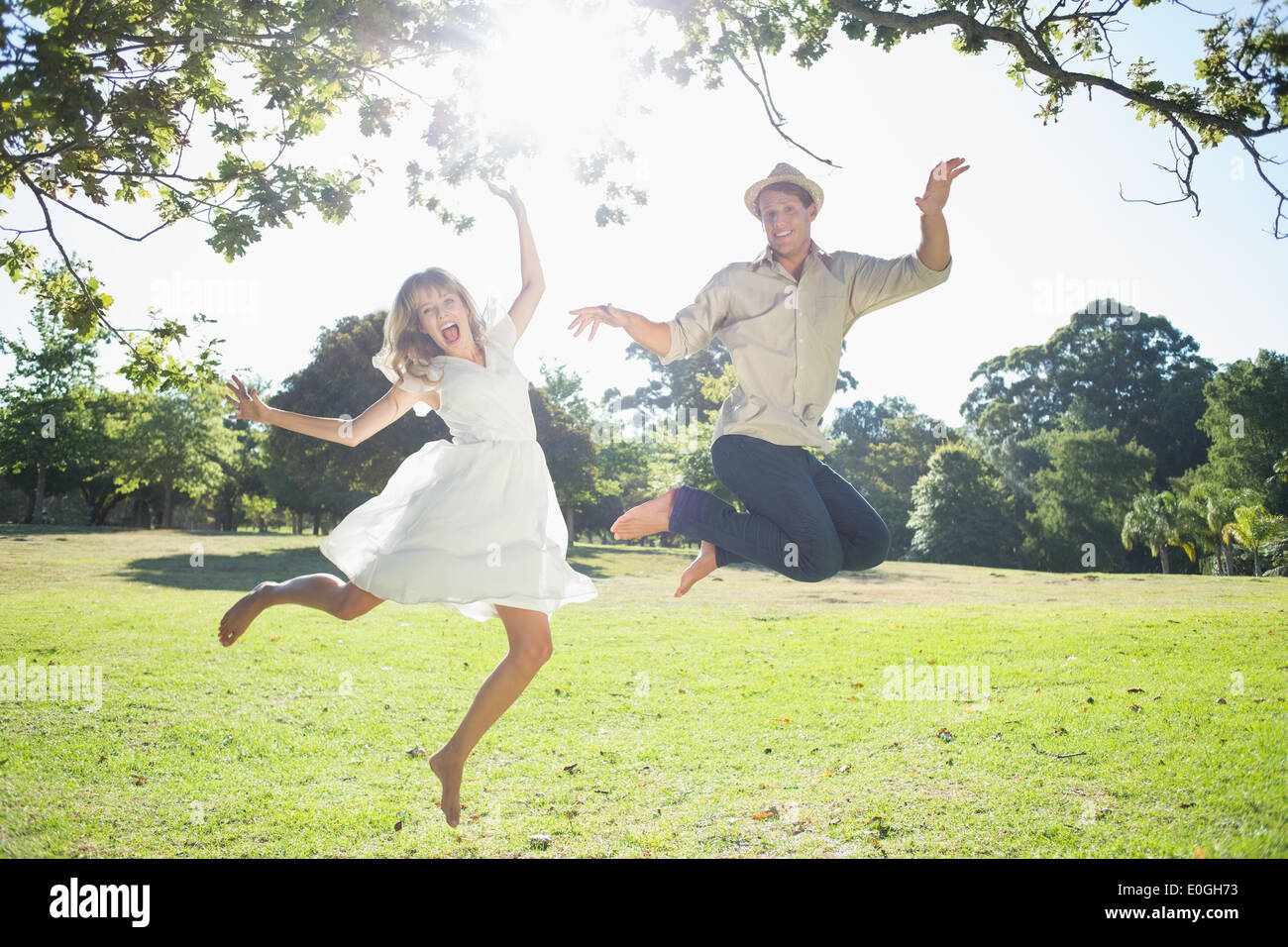 Cute couple jumping in the park together Stock Photo - Alamy
