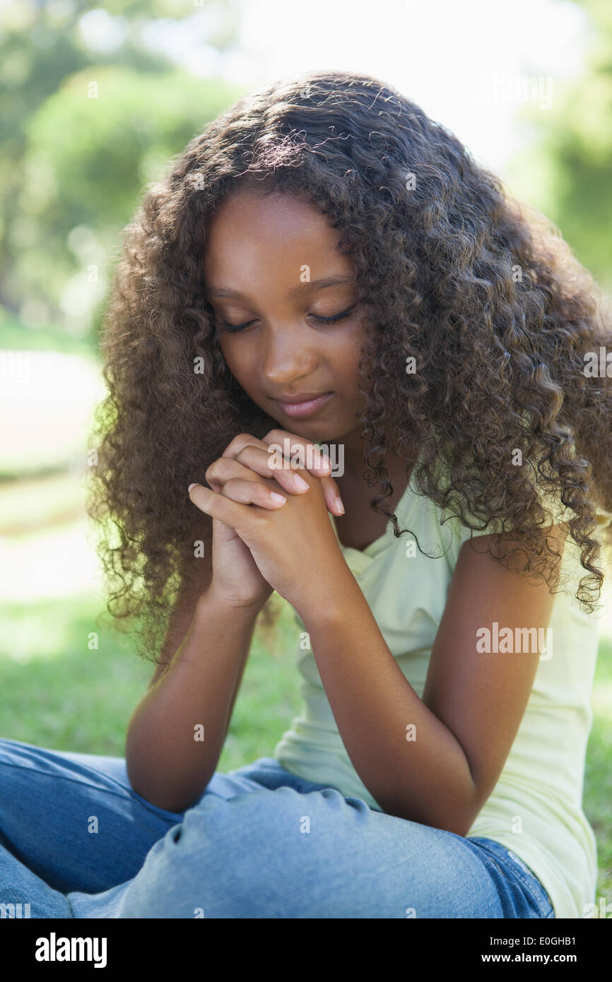 Young girl praying in the park Stock Photo - Alamy
