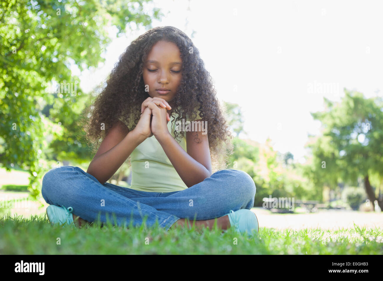 Young girl praying in the park Stock Photo - Alamy