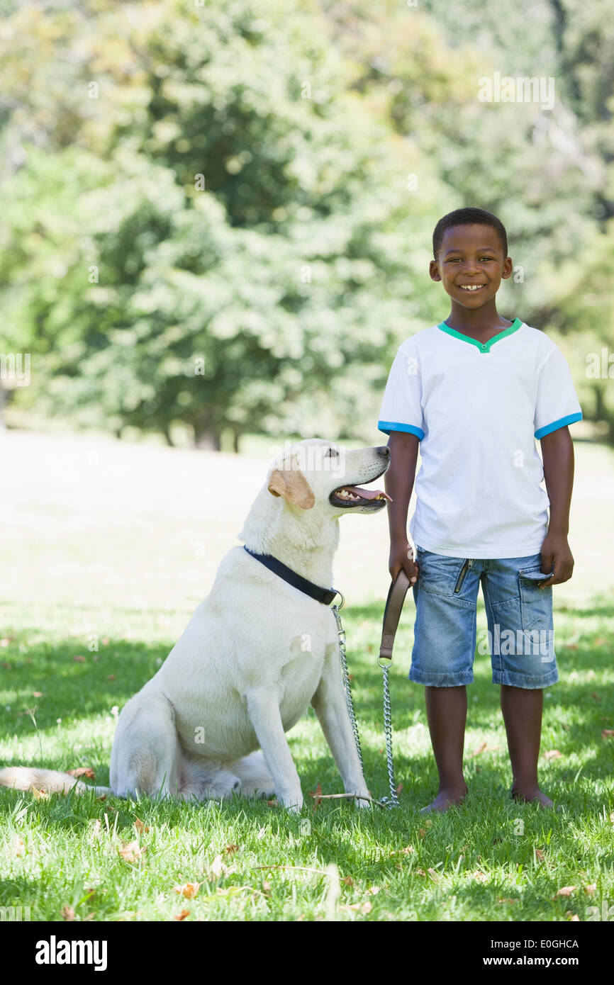 Little boy standing with his pet labrador in the park Stock Photo - Alamy