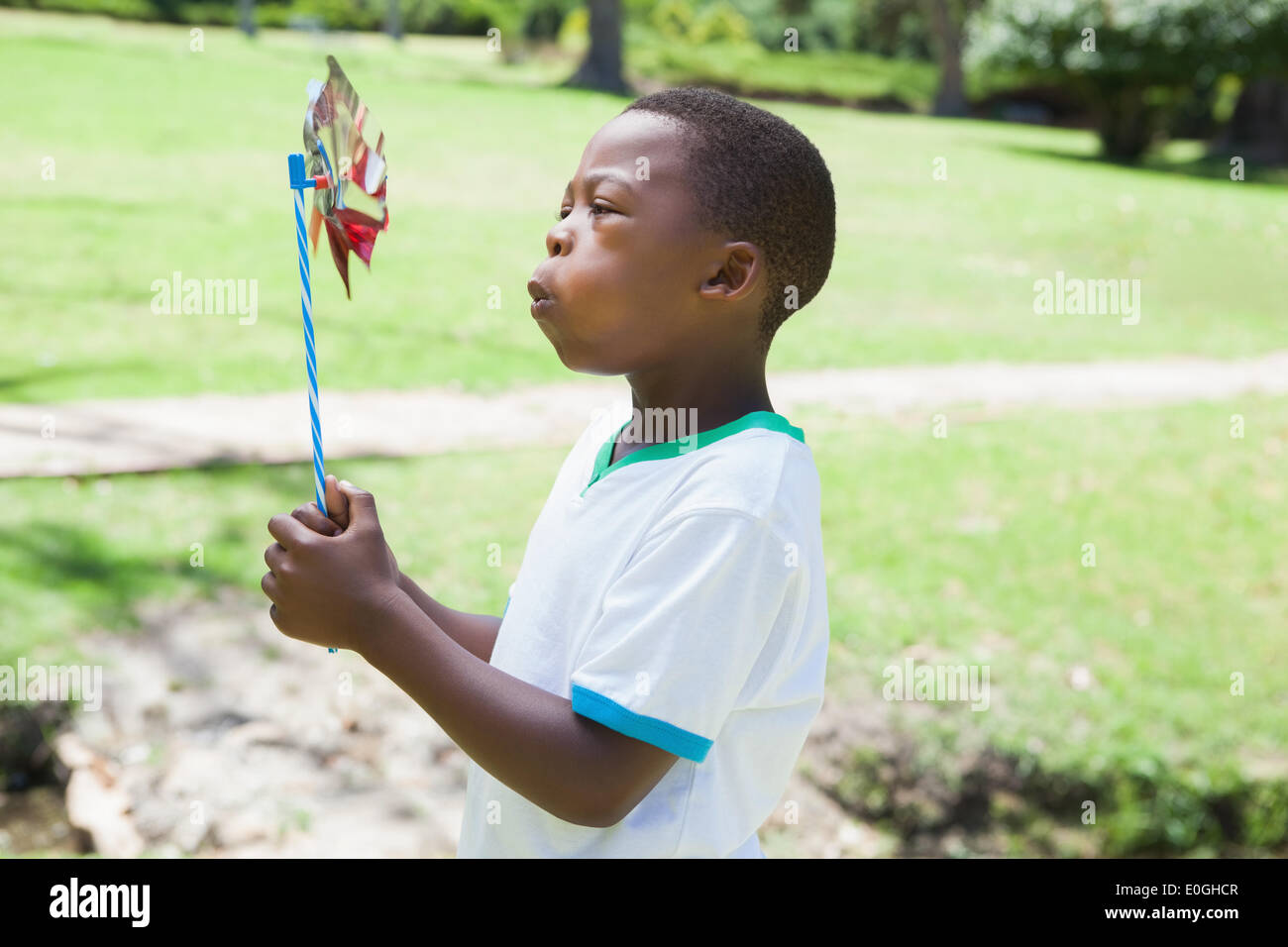 Little boy blowing pinwheel in the park Stock Photo - Alamy