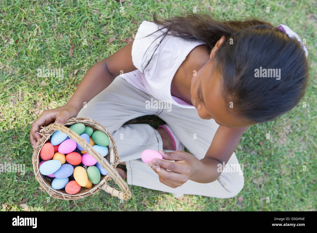 Little girl sitting on grass counting easter eggs Stock Photo - Alamy