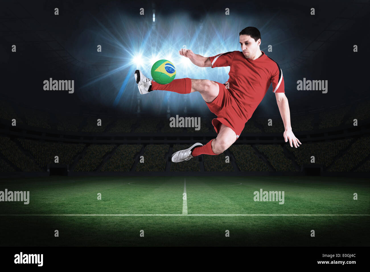 Fit football player jumping and kicking Stock Photo - Alamy