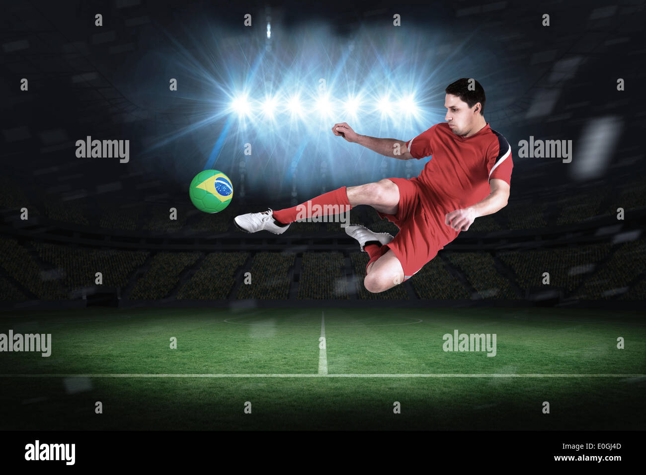 Fit football player jumping and kicking Stock Photo - Alamy