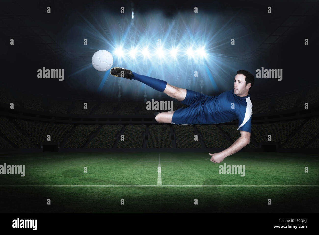 Football player in blue kicking Stock Photo - Alamy