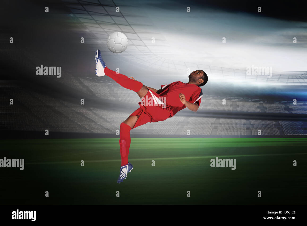 Football player in red kicking Stock Photo - Alamy