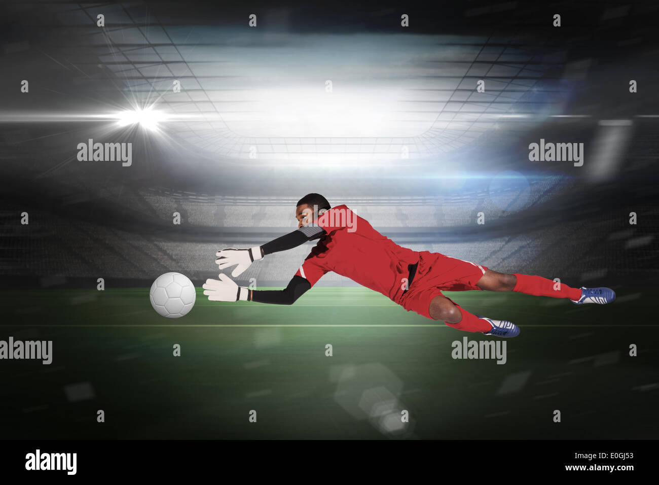 Goalkeeper in red making a save Stock Photo - Alamy