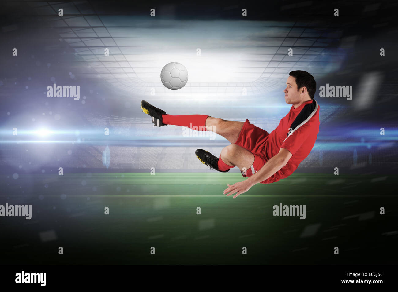 Football player in red kicking Stock Photo - Alamy