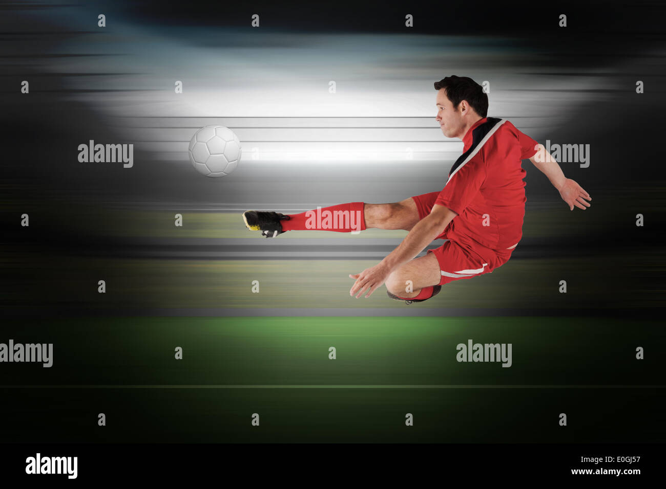 Football player in red kicking Stock Photo - Alamy