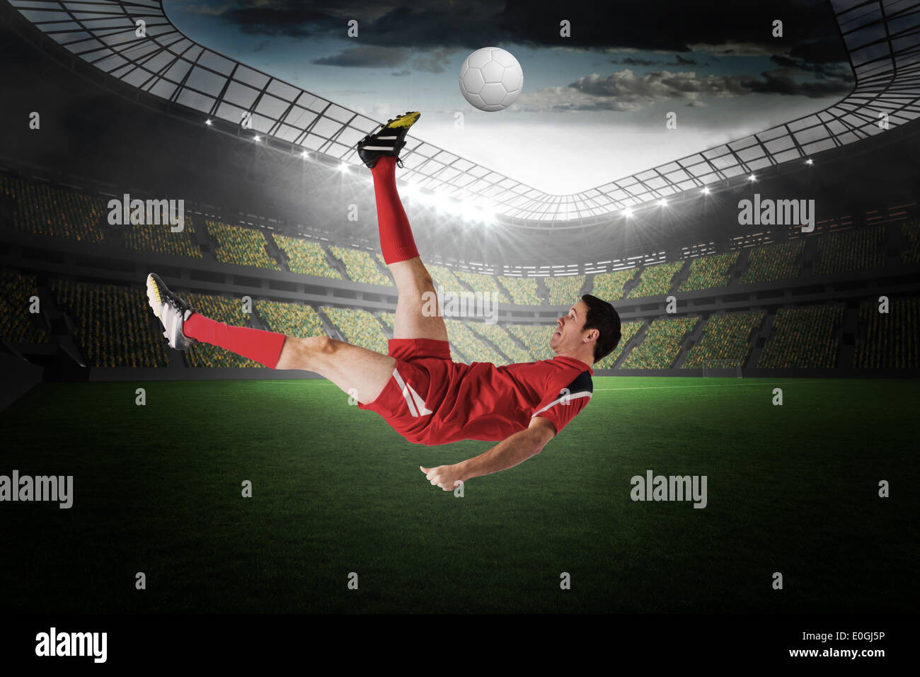 Football player in red kicking Stock Photo - Alamy