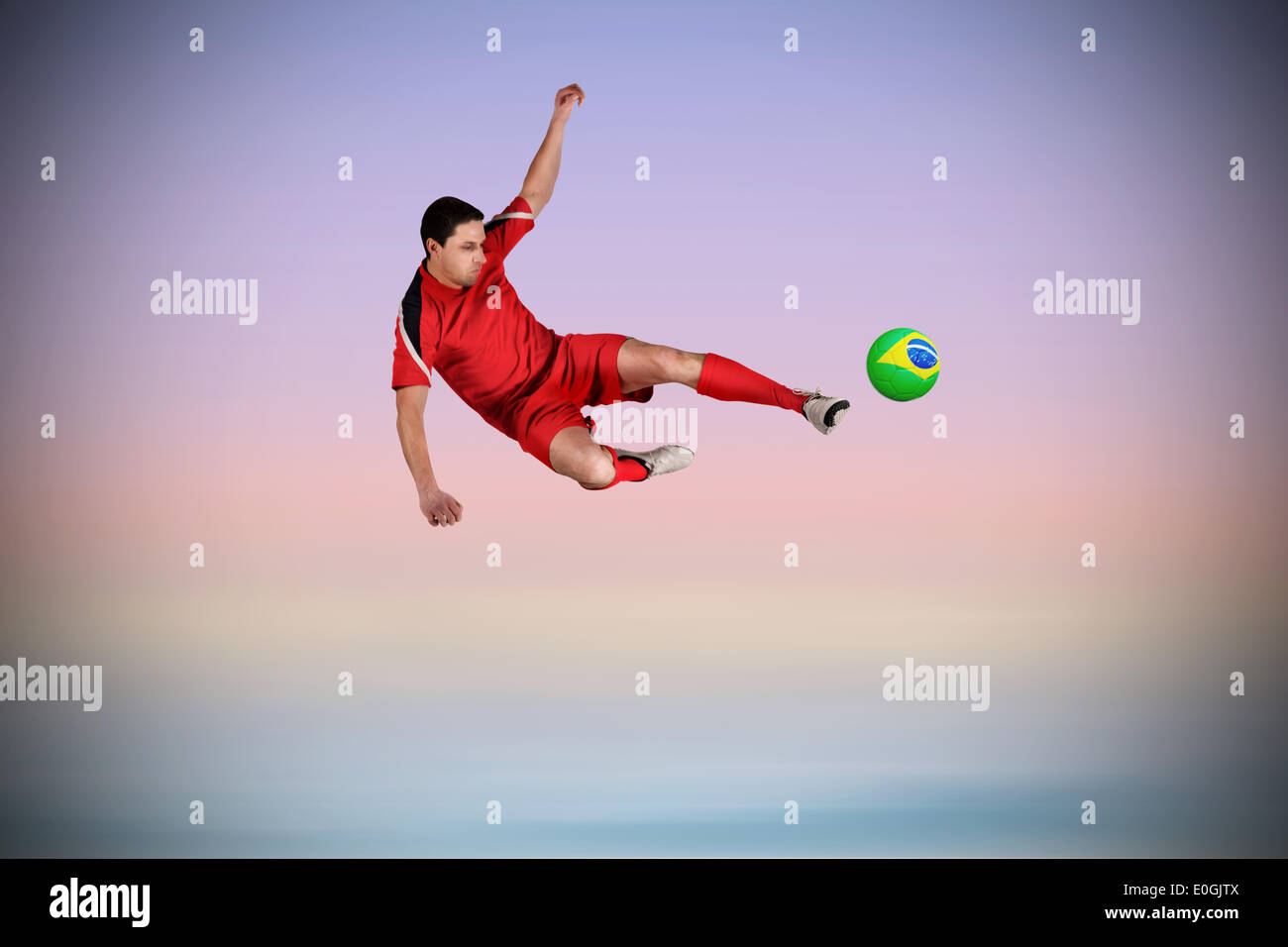 Fit football player jumping and kicking Stock Photo - Alamy
