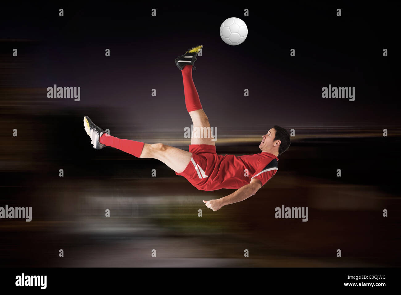 Football player in red kicking Stock Photo - Alamy