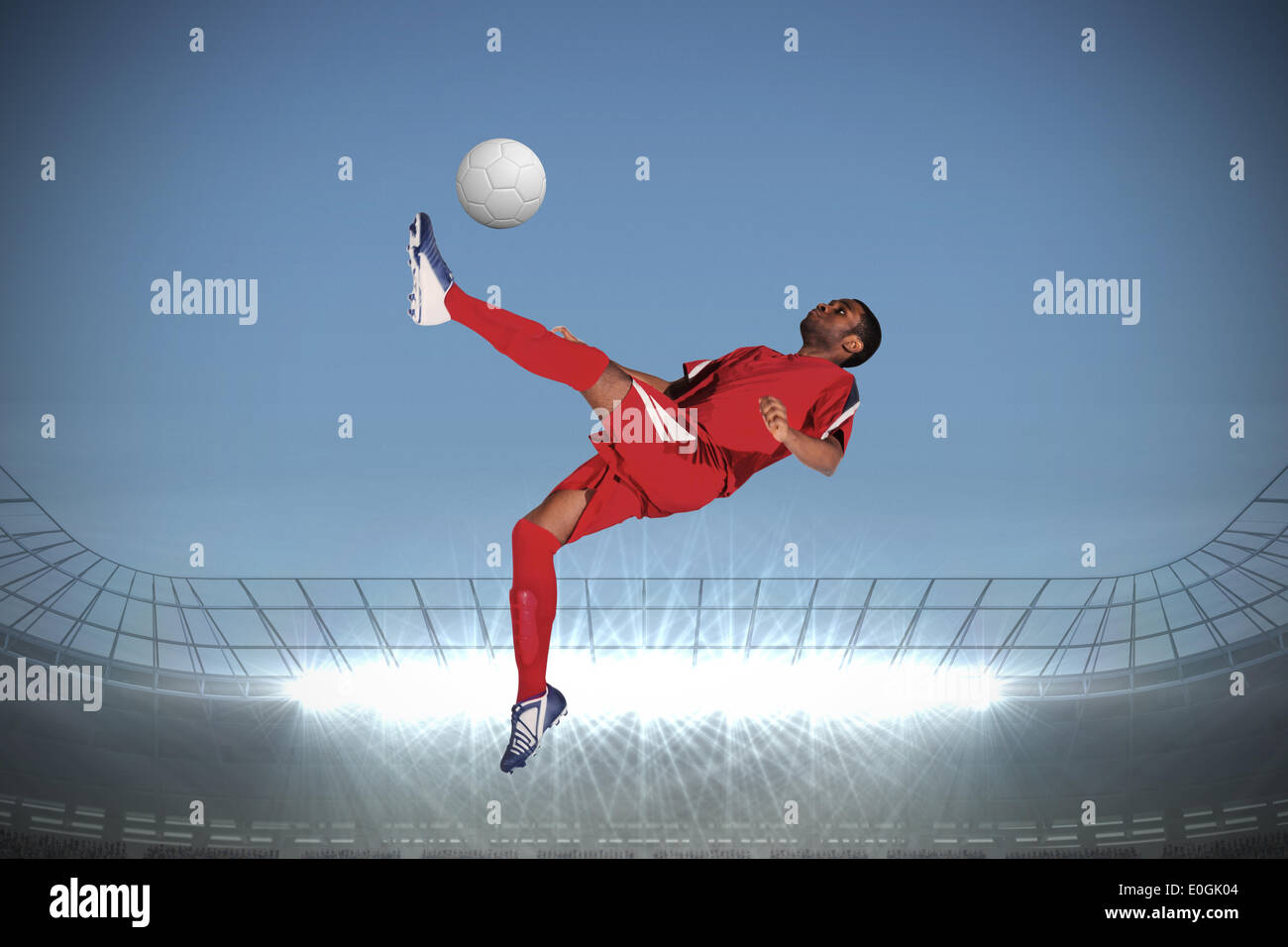 Football player in red kicking Stock Photo - Alamy