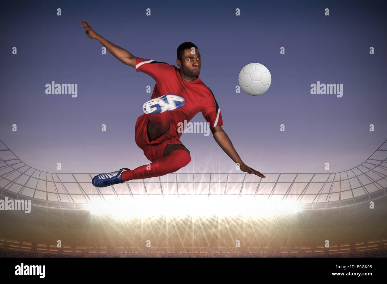 Football player in red kicking Stock Photo - Alamy