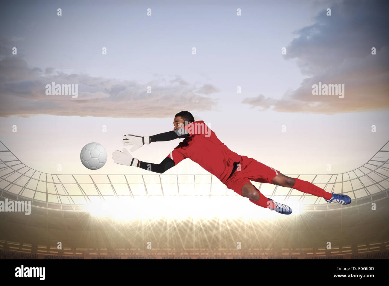 Goalkeeper in red making a save Stock Photo - Alamy