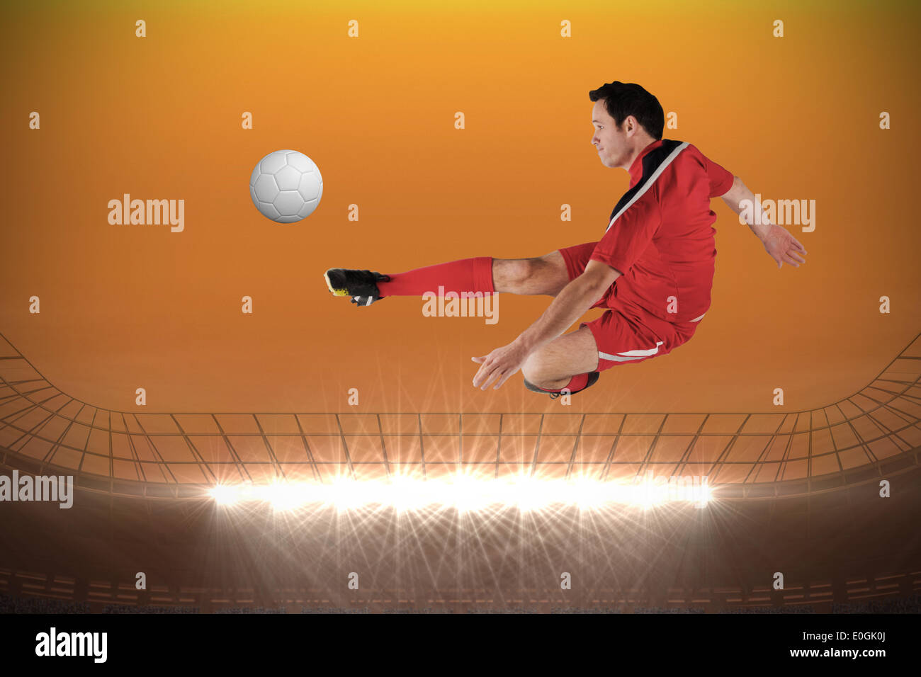 Football player in red kicking Stock Photo - Alamy