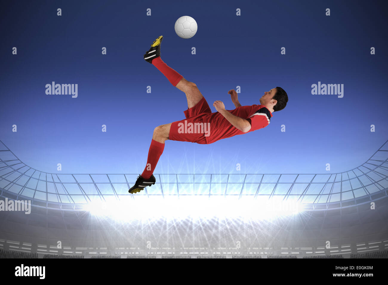 Football player in red kicking Stock Photo - Alamy