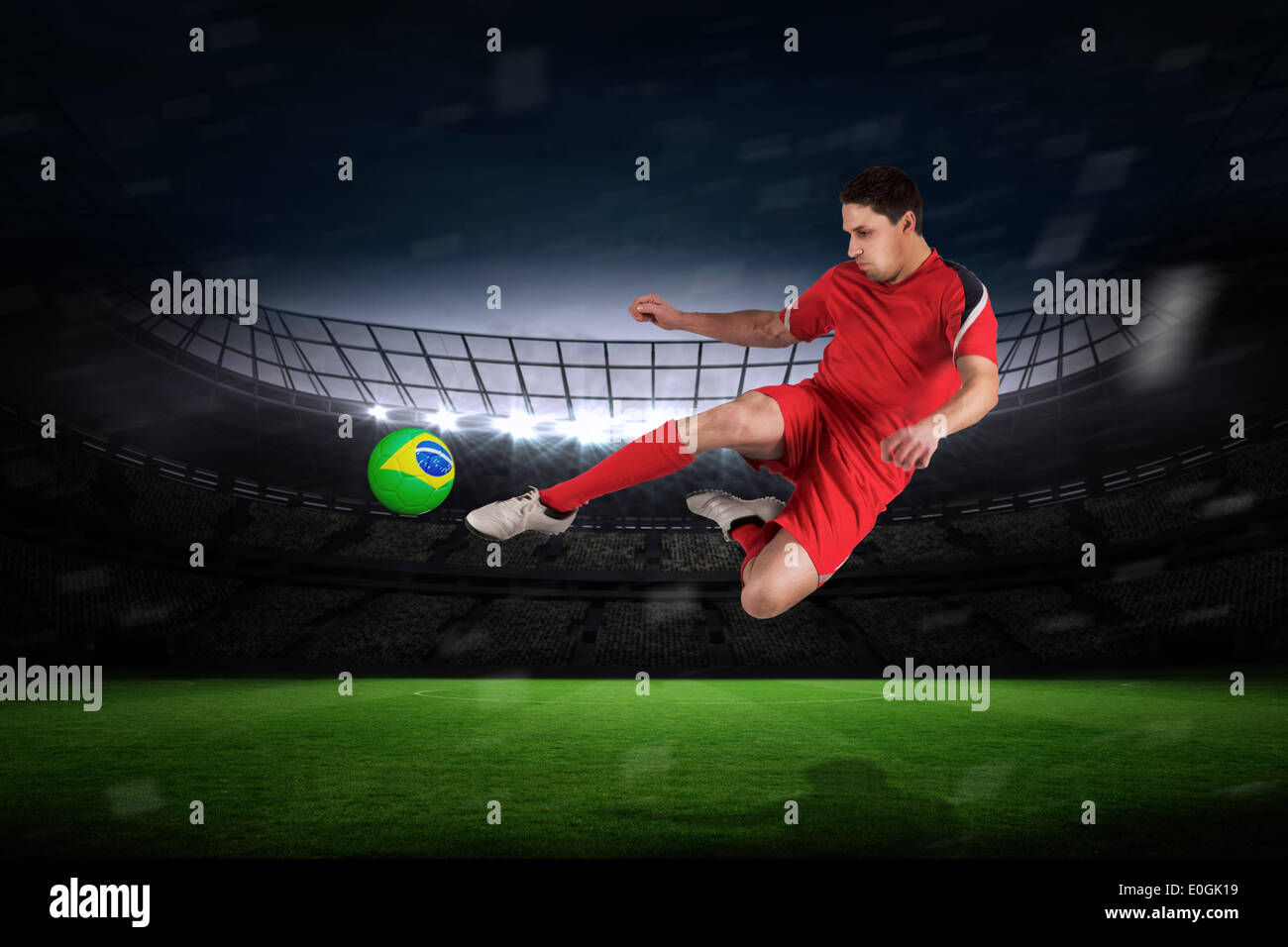 Fit football player jumping and kicking Stock Photo - Alamy