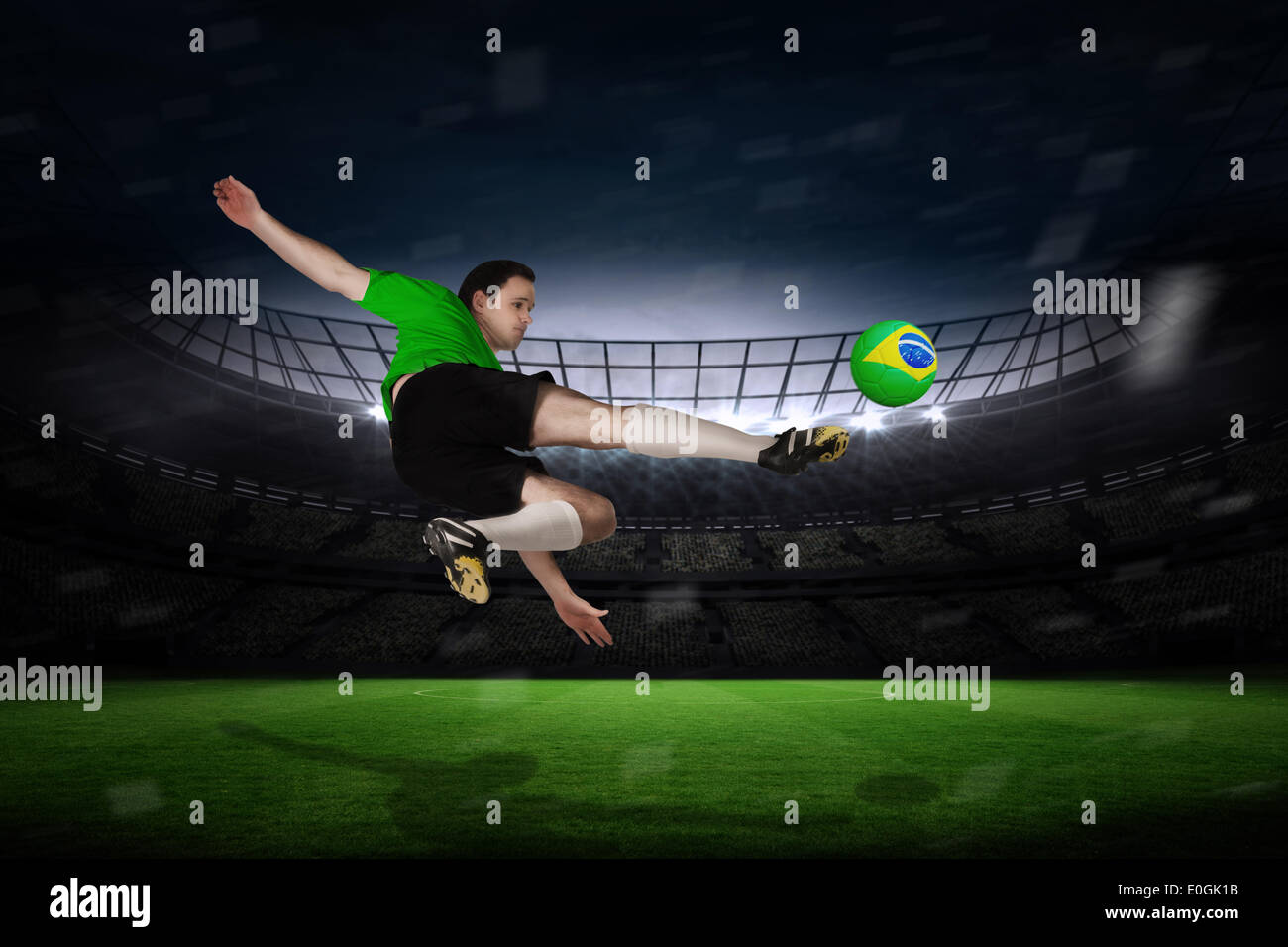 Football player in green kicking Stock Photo - Alamy