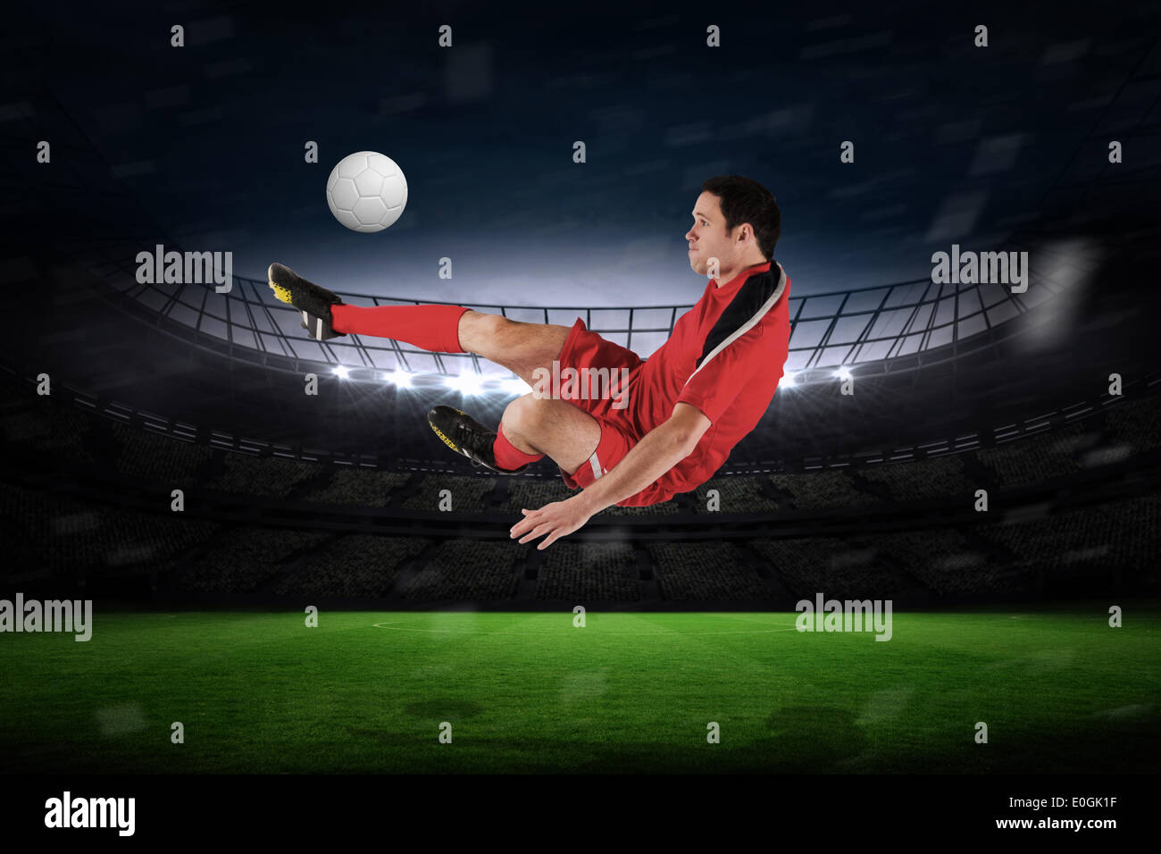 Football player in red kicking Stock Photo - Alamy