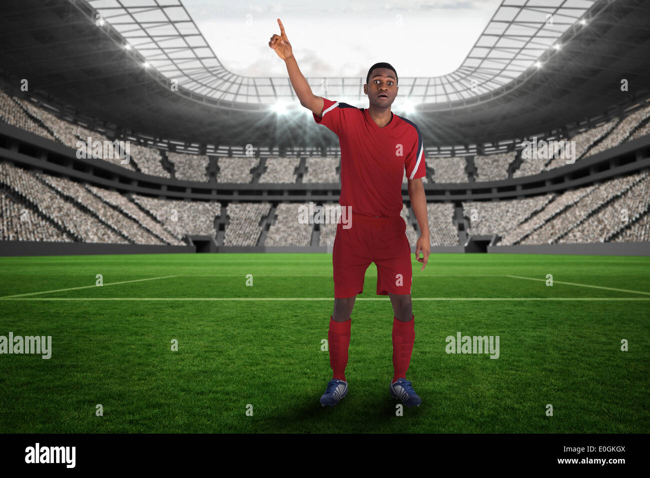 Football player in red raising his hand Stock Photo - Alamy