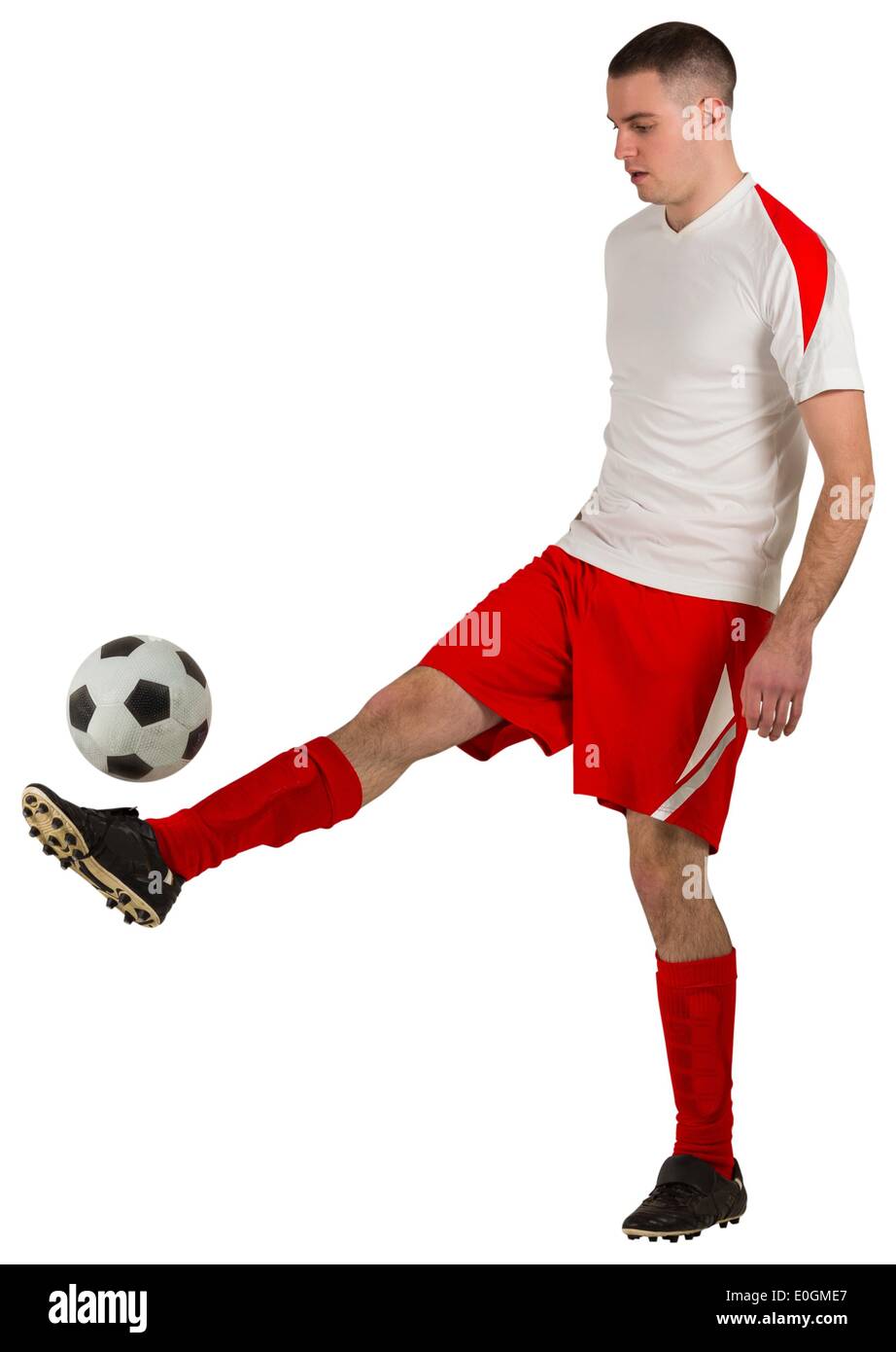 Fit football player playing with ball Stock Photo - Alamy