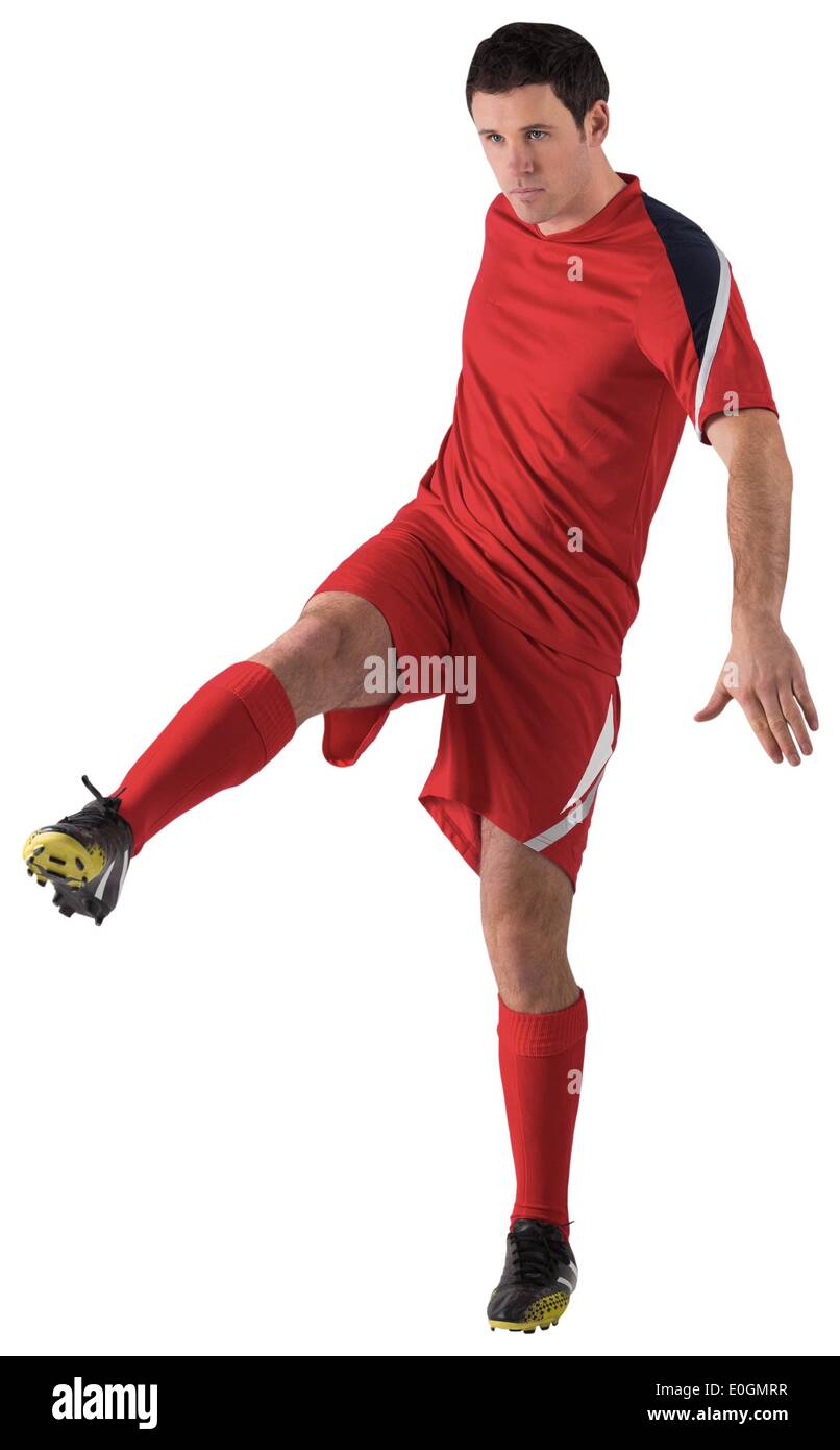 Football player in red kicking Stock Photo - Alamy