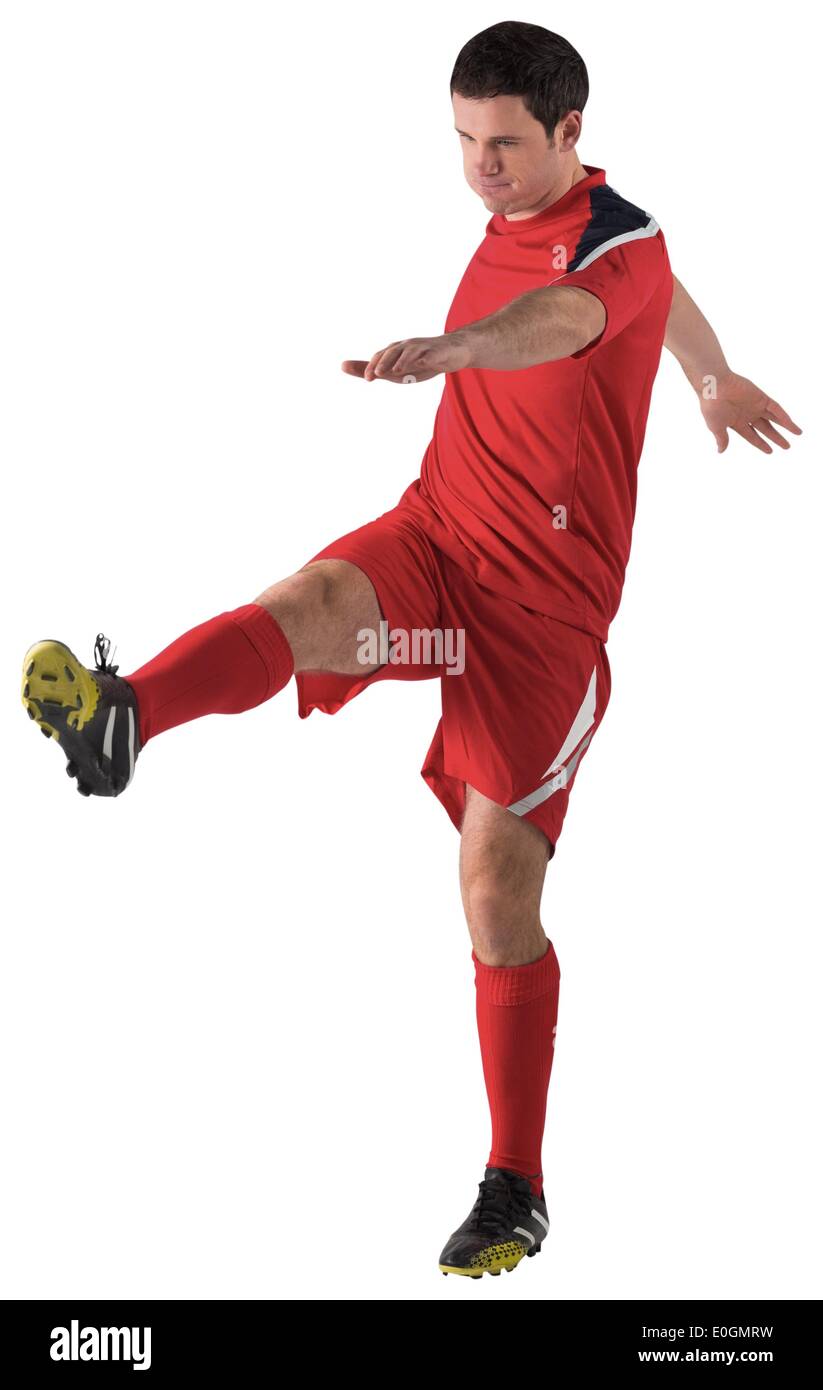 Football player in red kicking Stock Photo - Alamy
