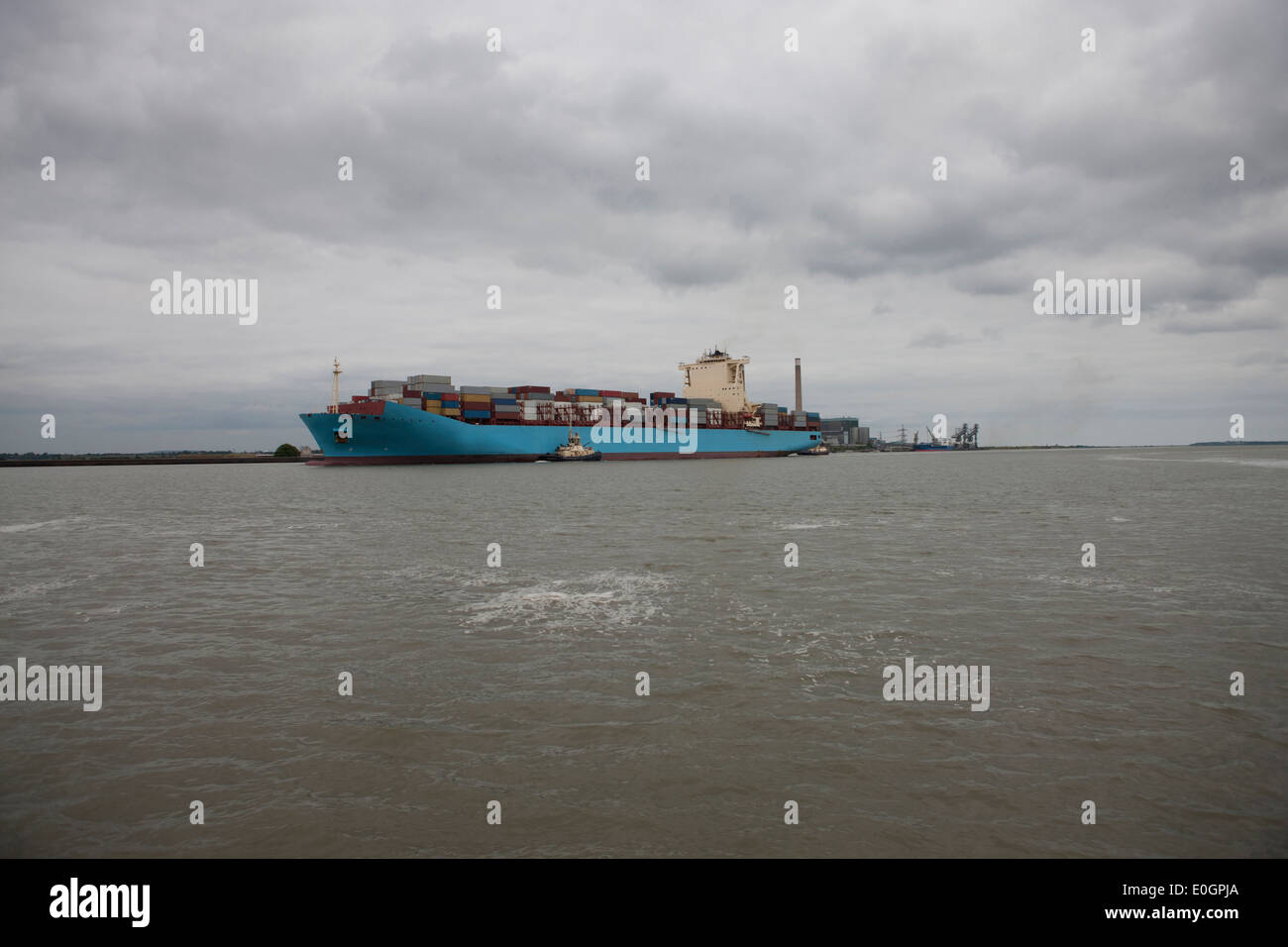 A container ship escorted by tug boats Stock Photo - Alamy