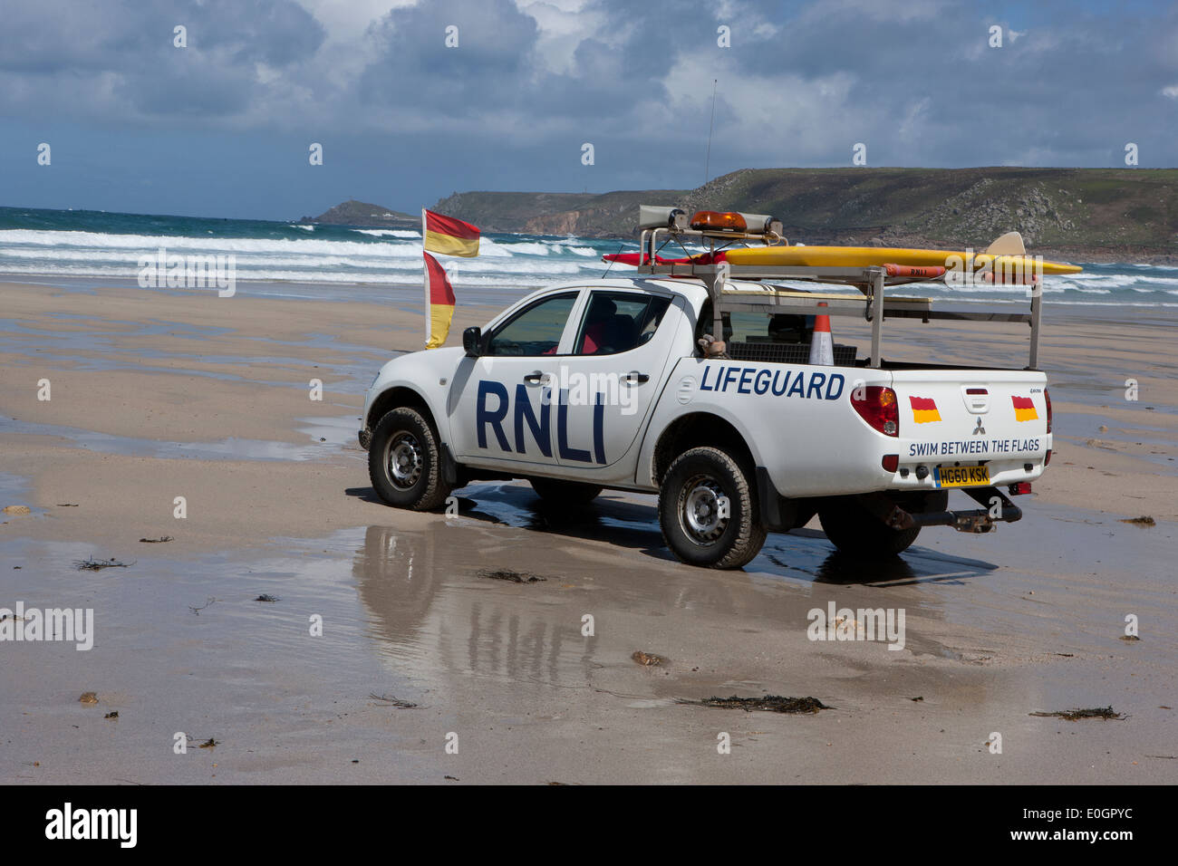 Lifeguards in a 4x4 pick-up with warning flags on a beach at Sennen ...
