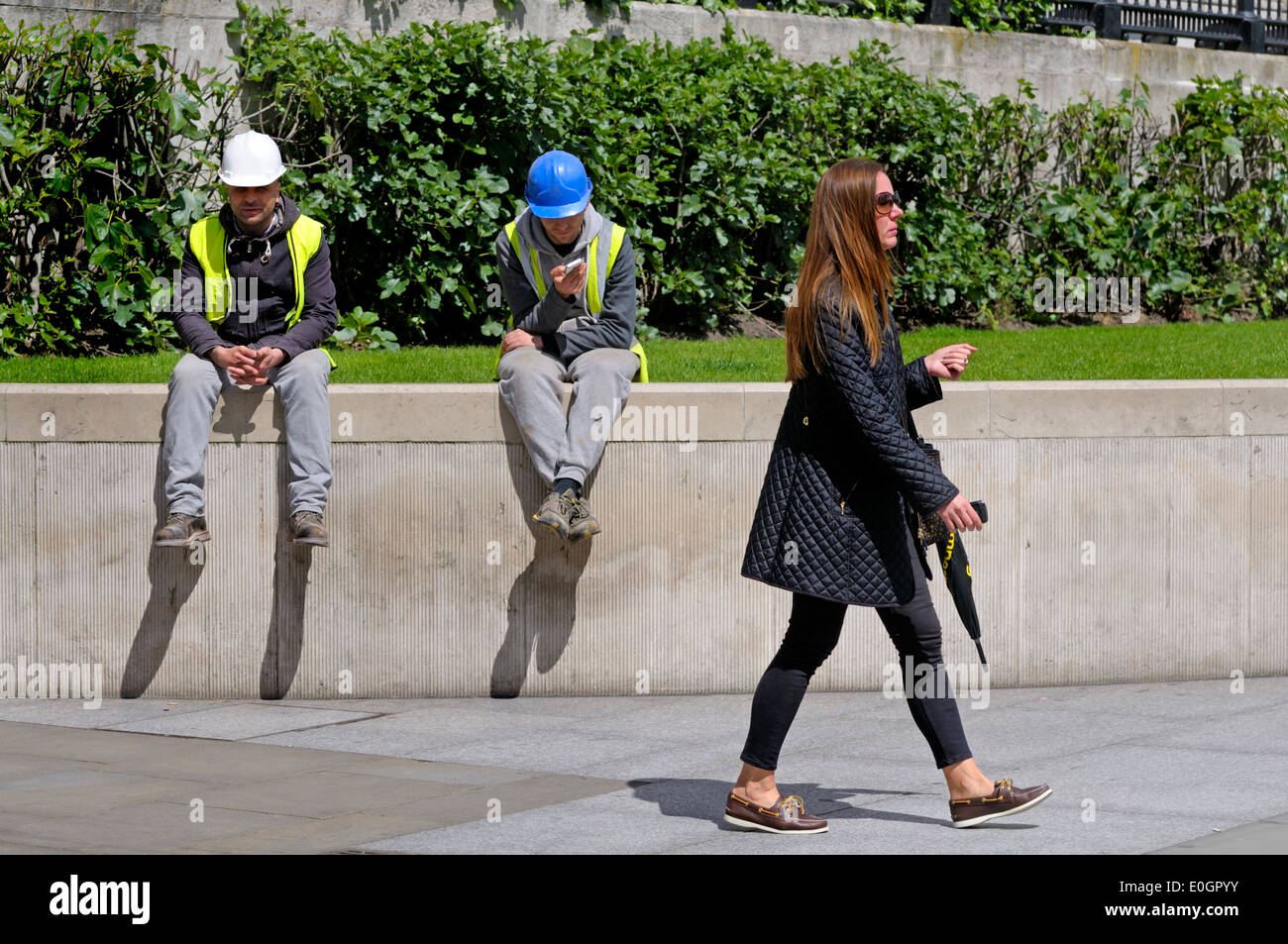 Young woman walking past workmen hi-res stock photography and images ...