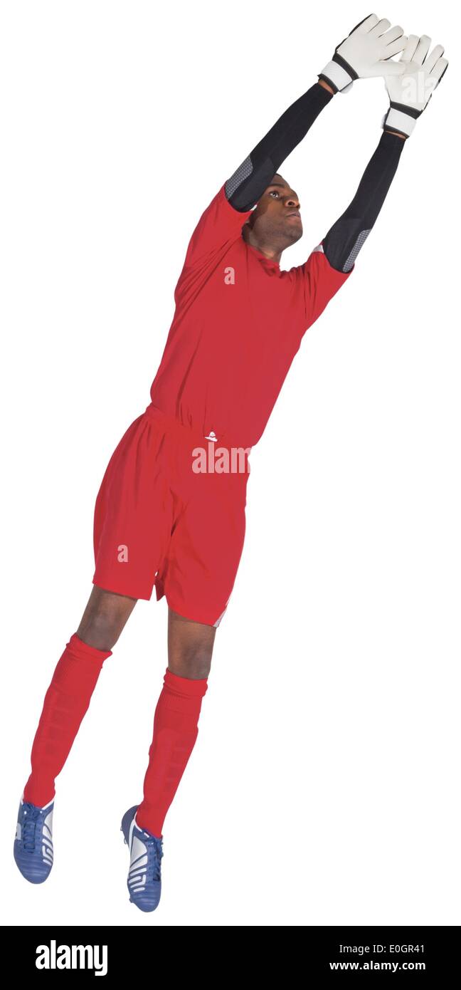 Goalkeeper in red making a save Stock Photo - Alamy