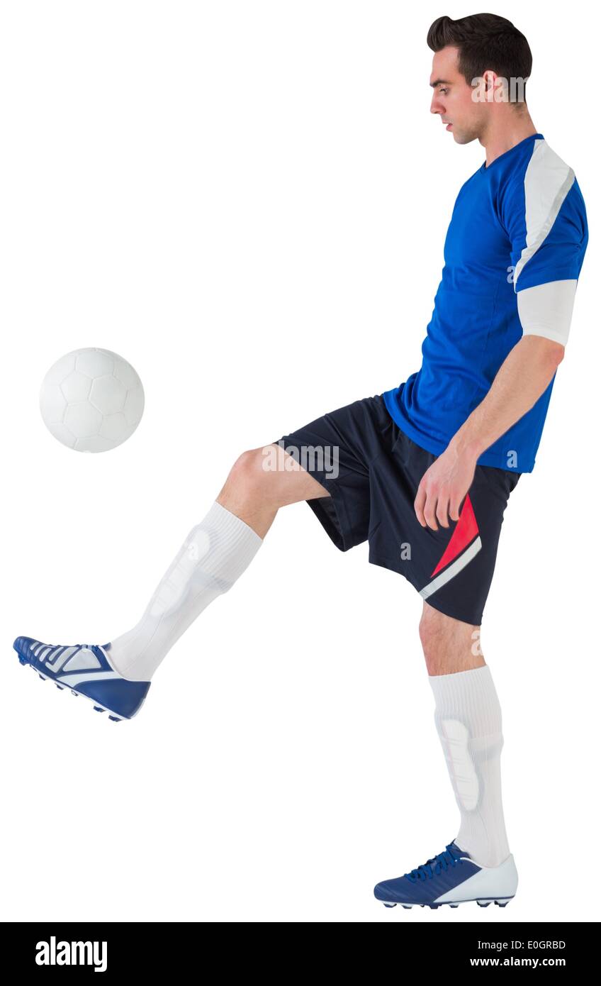 Football player in blue kicking ball Stock Photo - Alamy