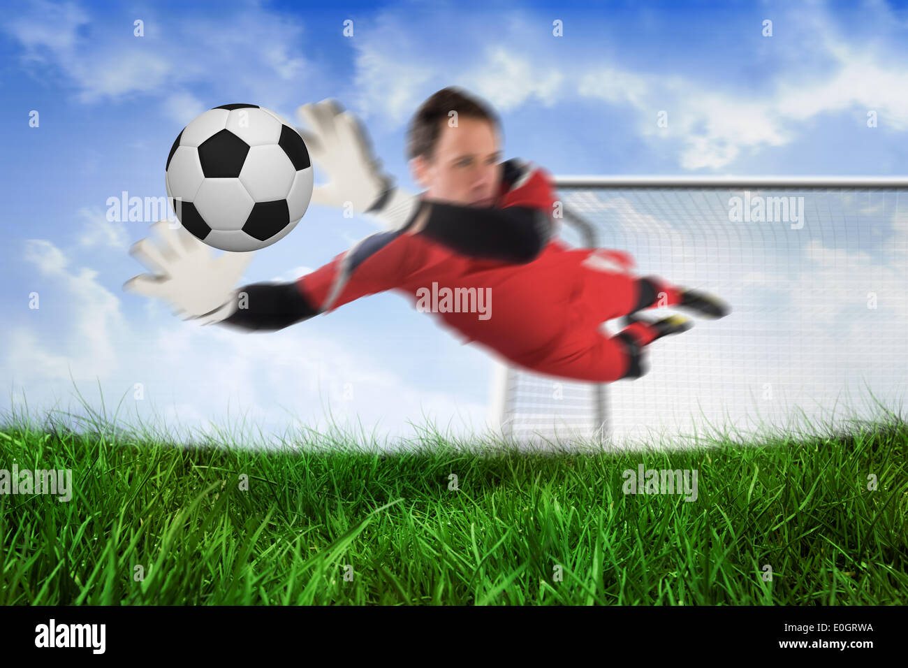 Fit goal keeper jumping up and saving ball Stock Photo - Alamy