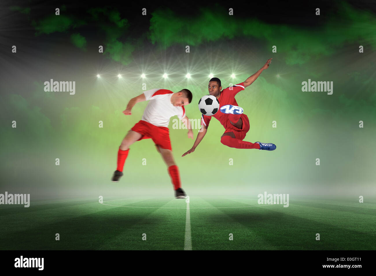 Football players tackling for the ball Stock Photo - Alamy