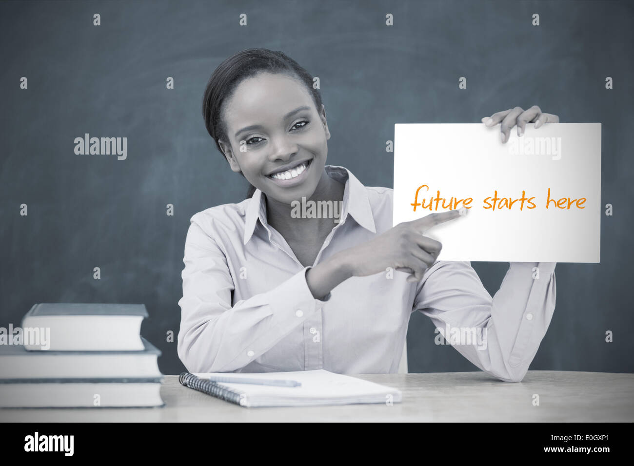 Happy teacher holding page showing future starts here Stock Photo - Alamy