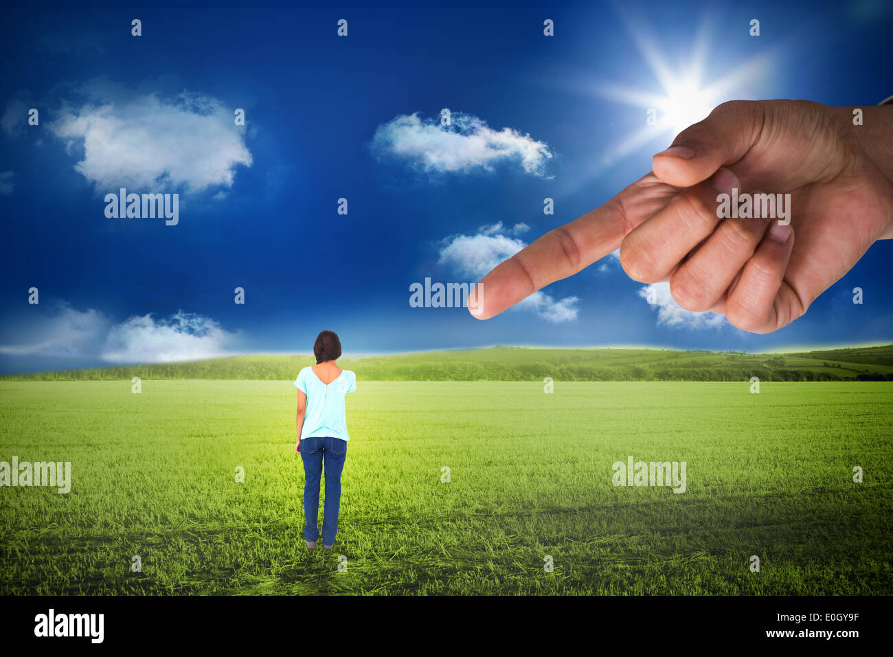 Giant hand pointing at casual brunette standing rear view Stock Photo ...