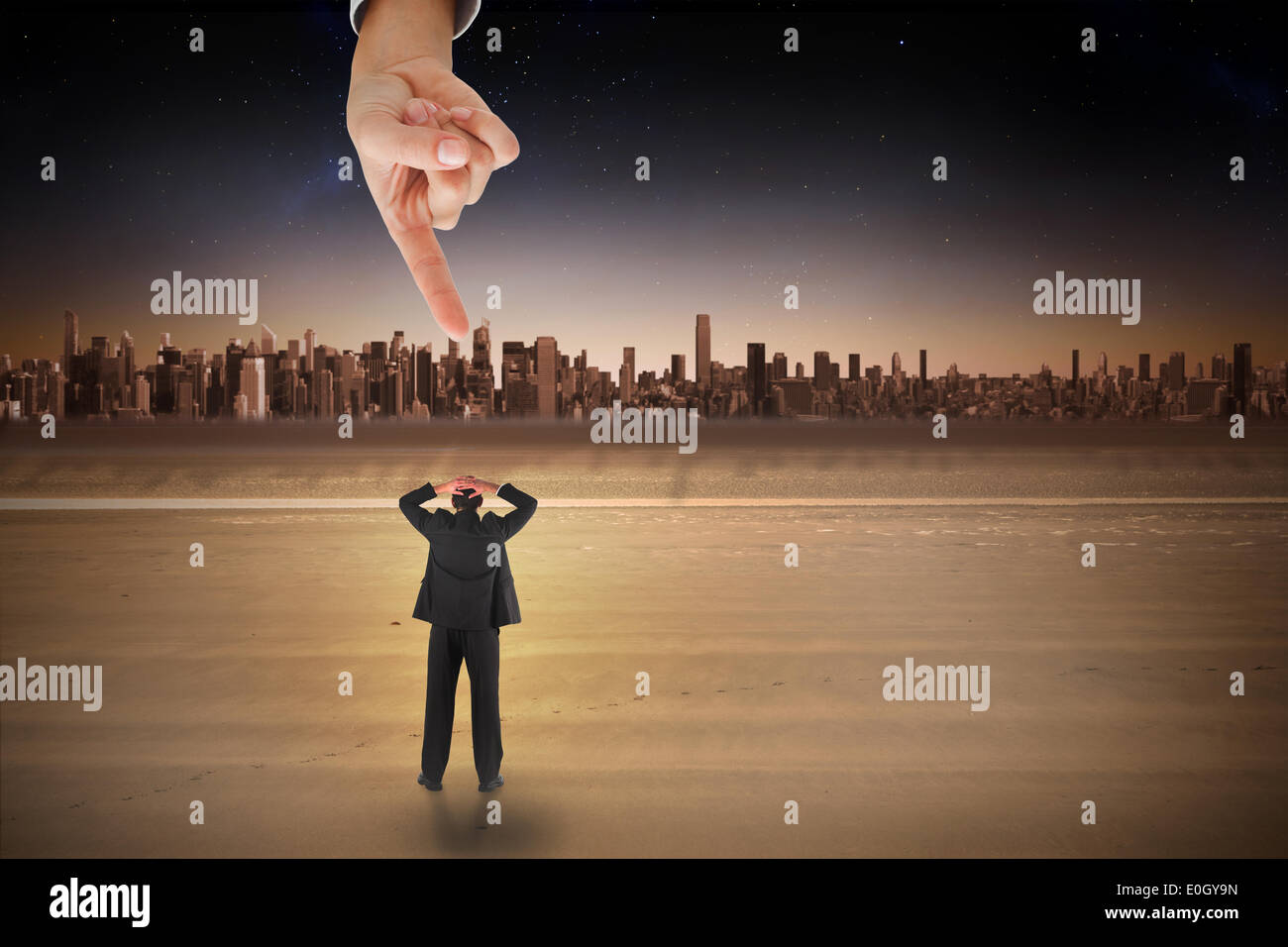 Giant hand pointing at businessman standing back to the camera with ...